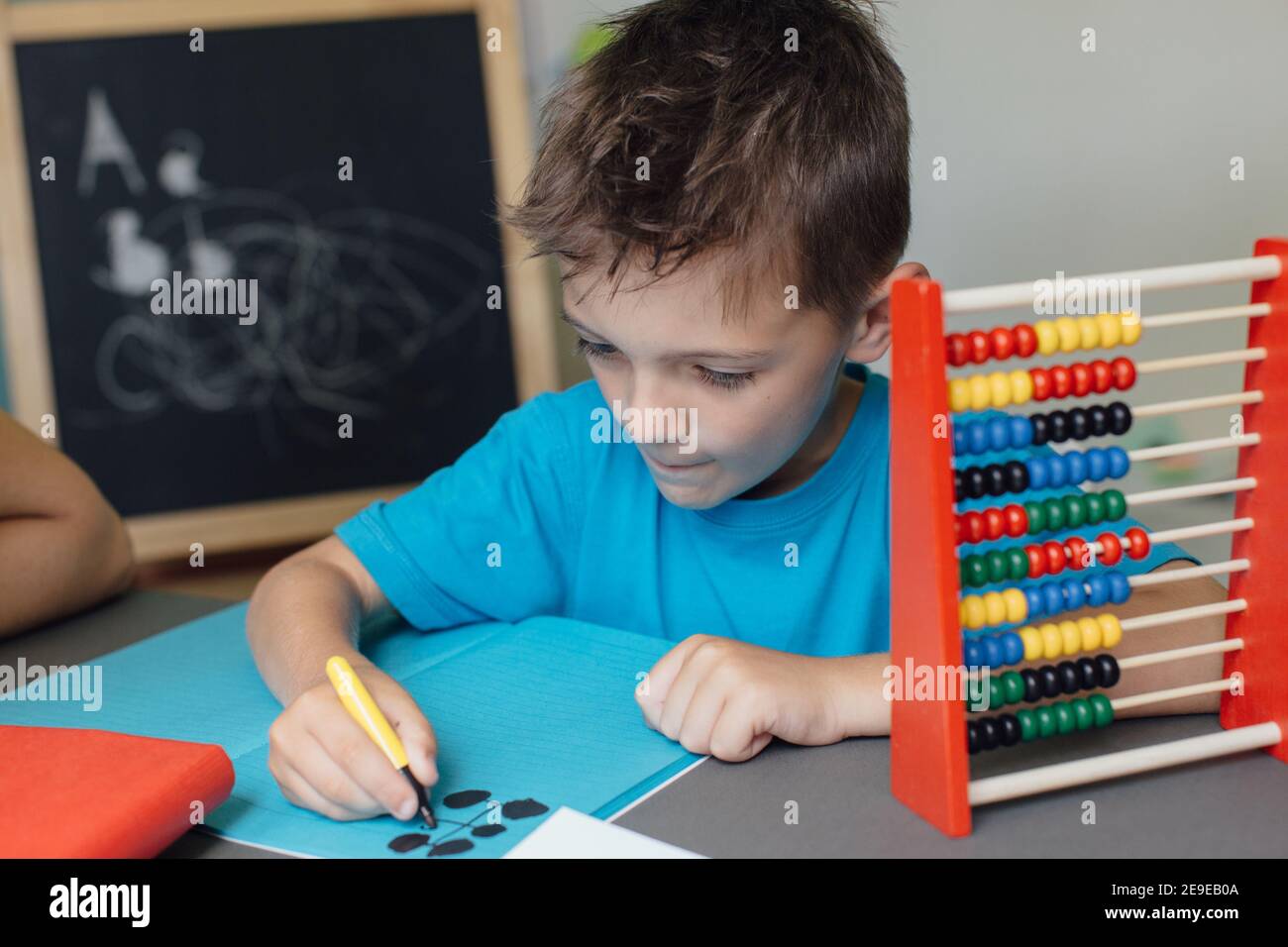 Focused schoolboy working on math homework Stock Photo - Alamy