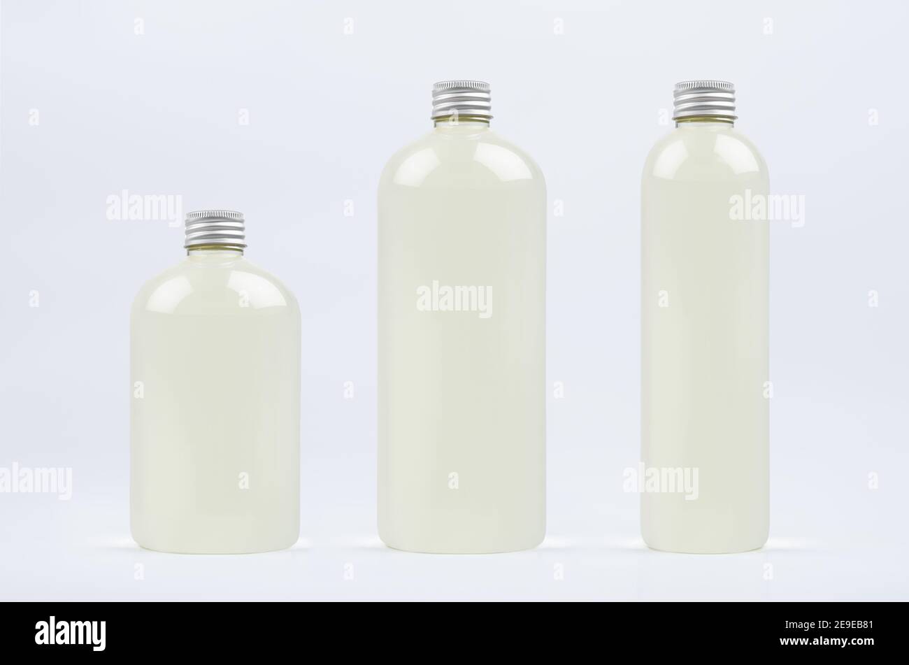 Assortment of three plastic tall, low and thick bottles with pale fresh ...