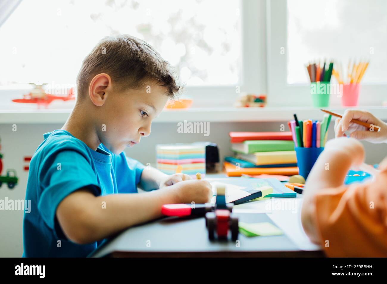 Side view of a whistling student doing his homework Stock Photo - Alamy