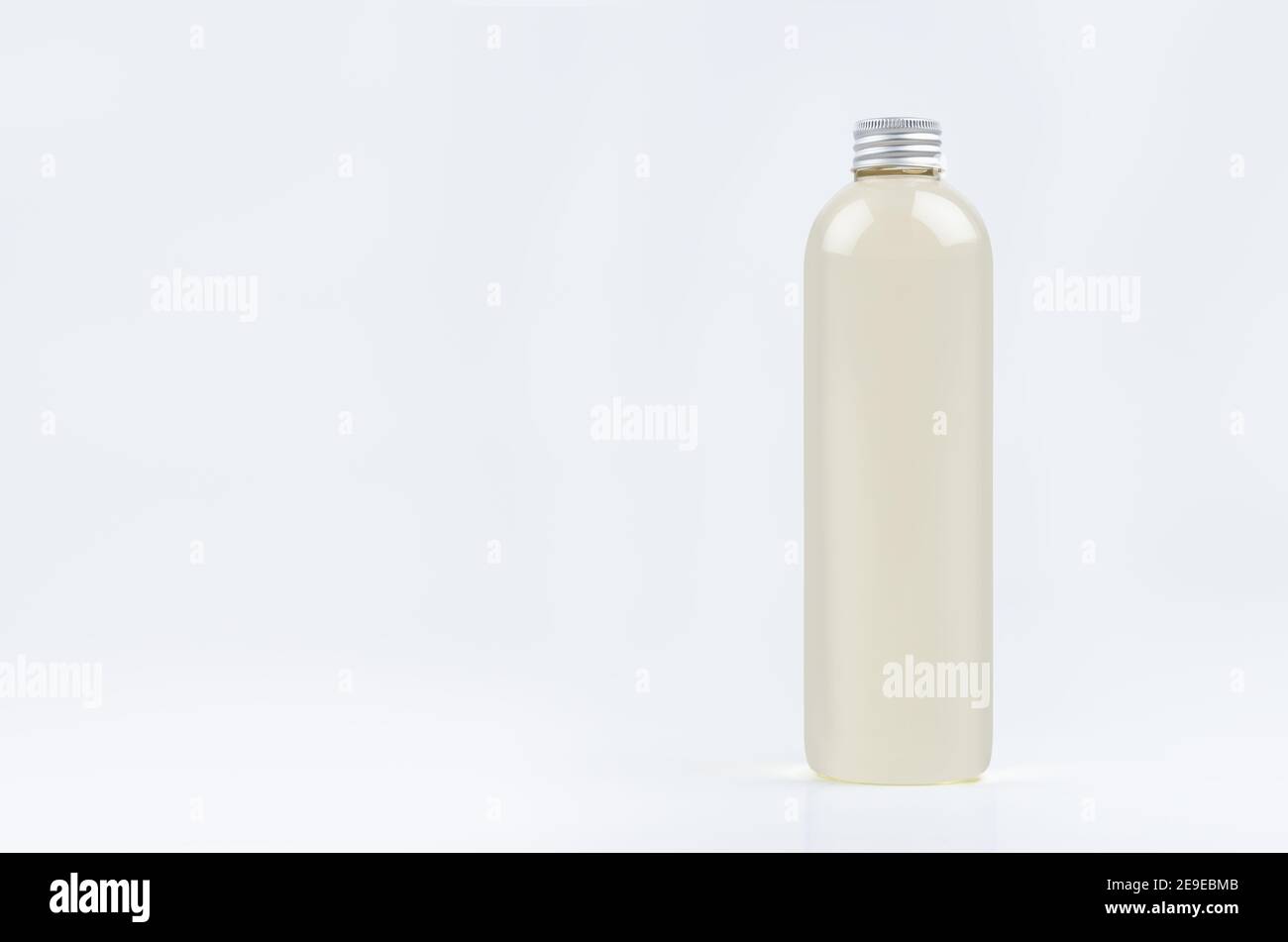 Transparent plastic tall thin bottle with pale fresh drink or cosmetic ...