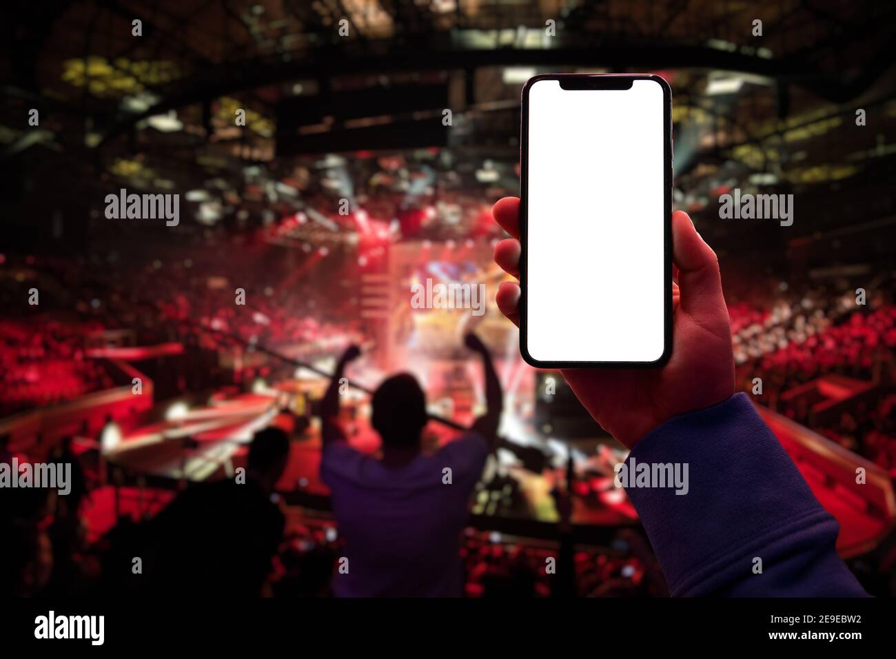 Gamer using smartphone during big esports gaming event sitting on the ...
