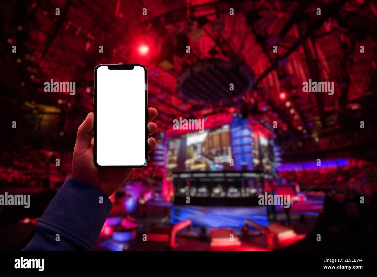Gamer using smartphone during big esports gaming event sitting on the ...
