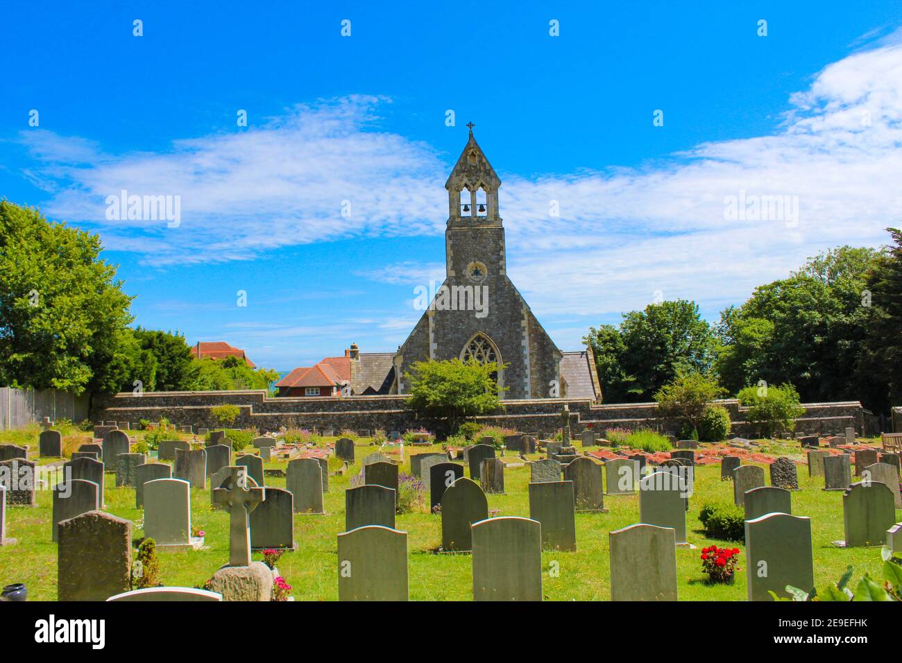 Exterior view of St John the Evangelist anglican church with tombstones ...