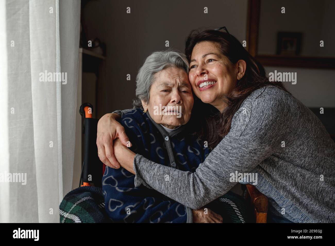 Woman hugging her mother in a wheelchair Stock Photo - Alamy