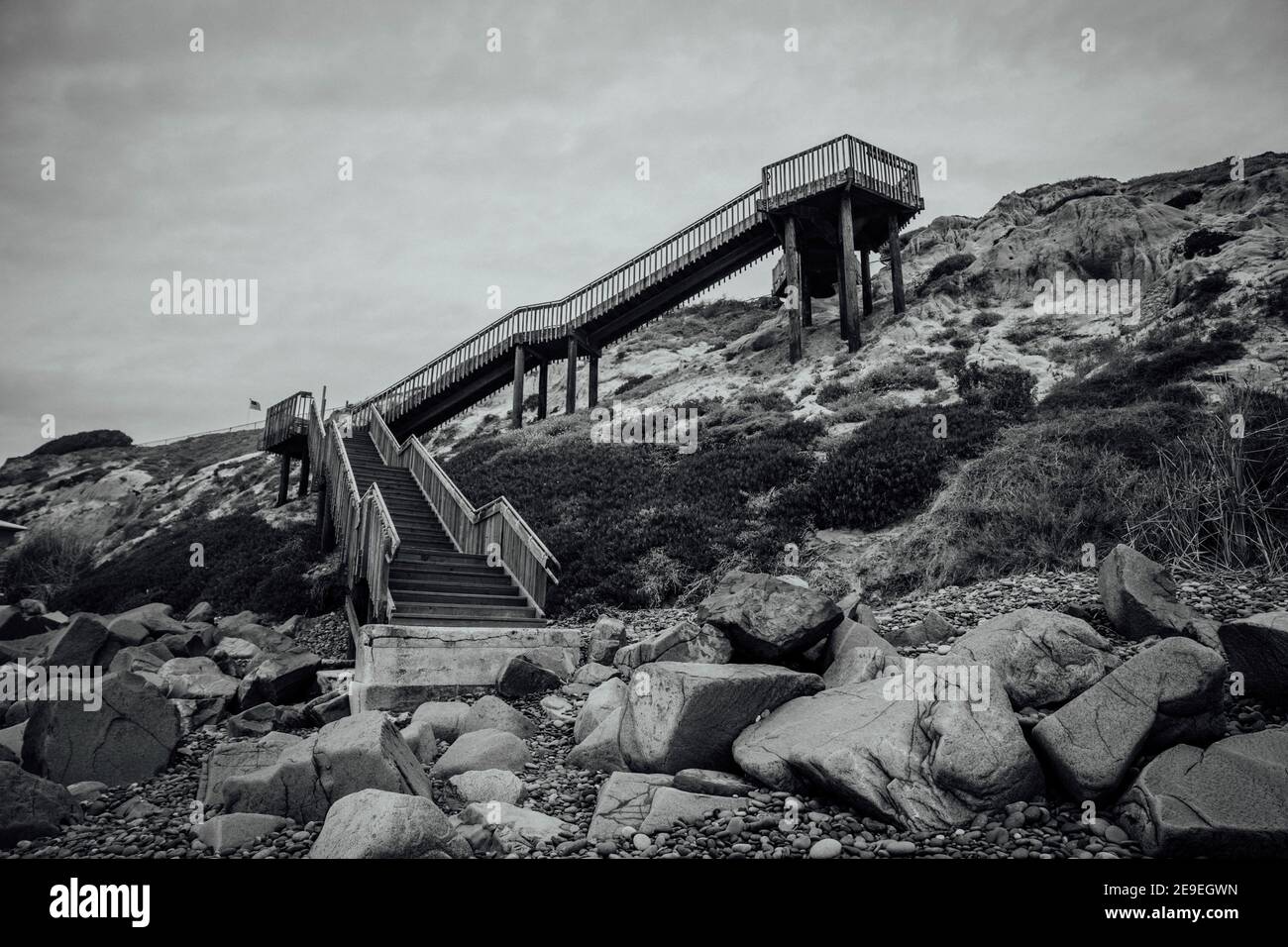 Grayscale shot of stairs leading to the top of a big rock scale Stock ...
