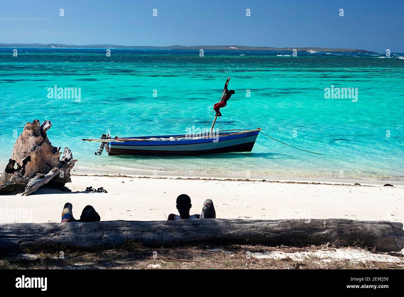 Wooden traditional fishing boat on a secluded sandy beach in a ...