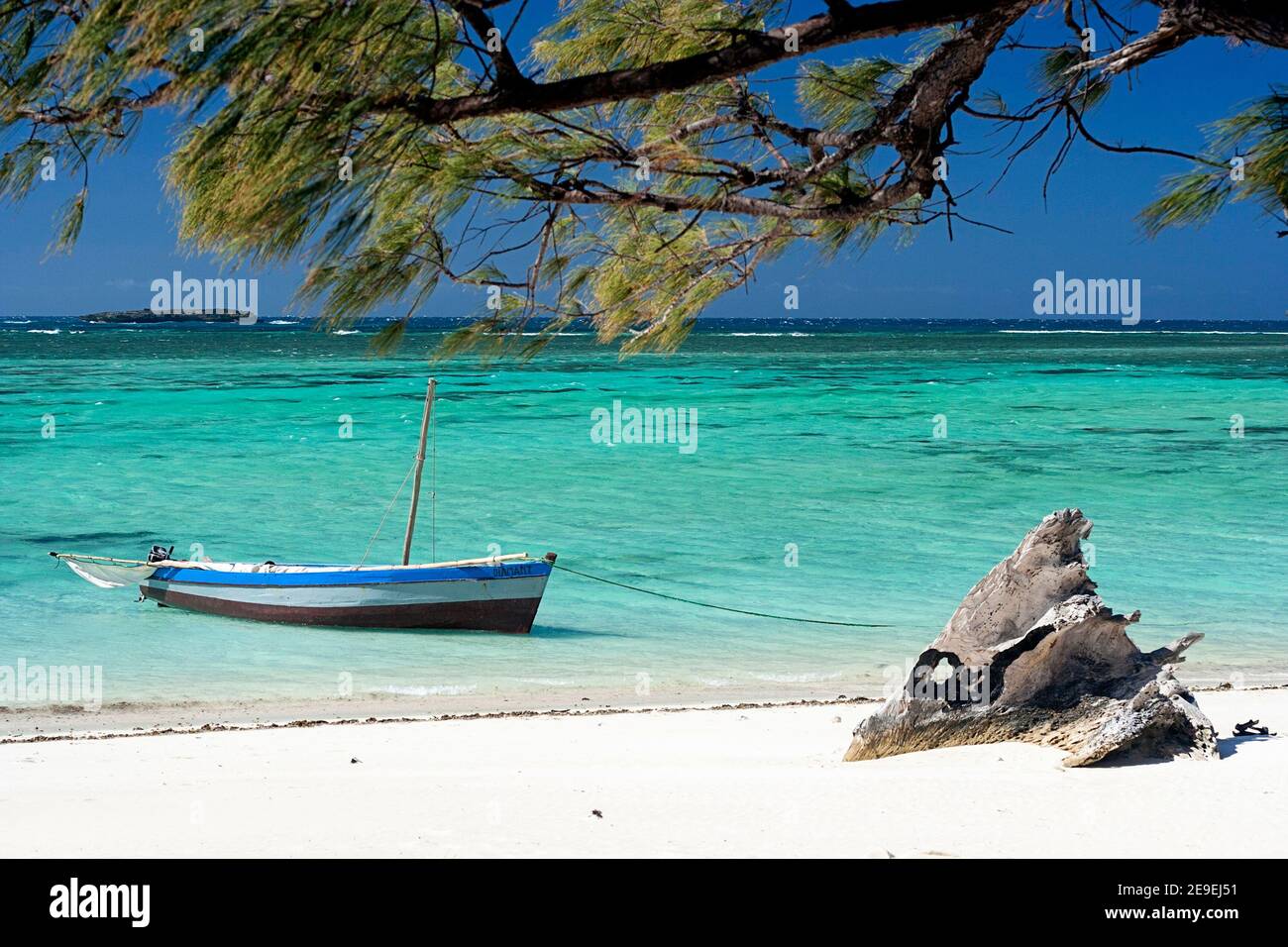 Wooden traditional fishing boat on a secluded sandy beach in a ...