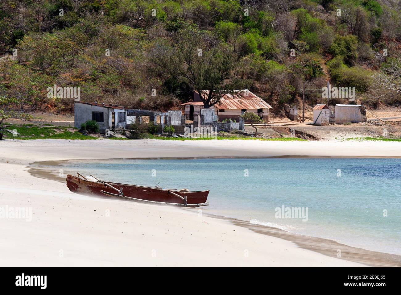 Traditional dugout canoe on a spectacular sandy orange beach with ...