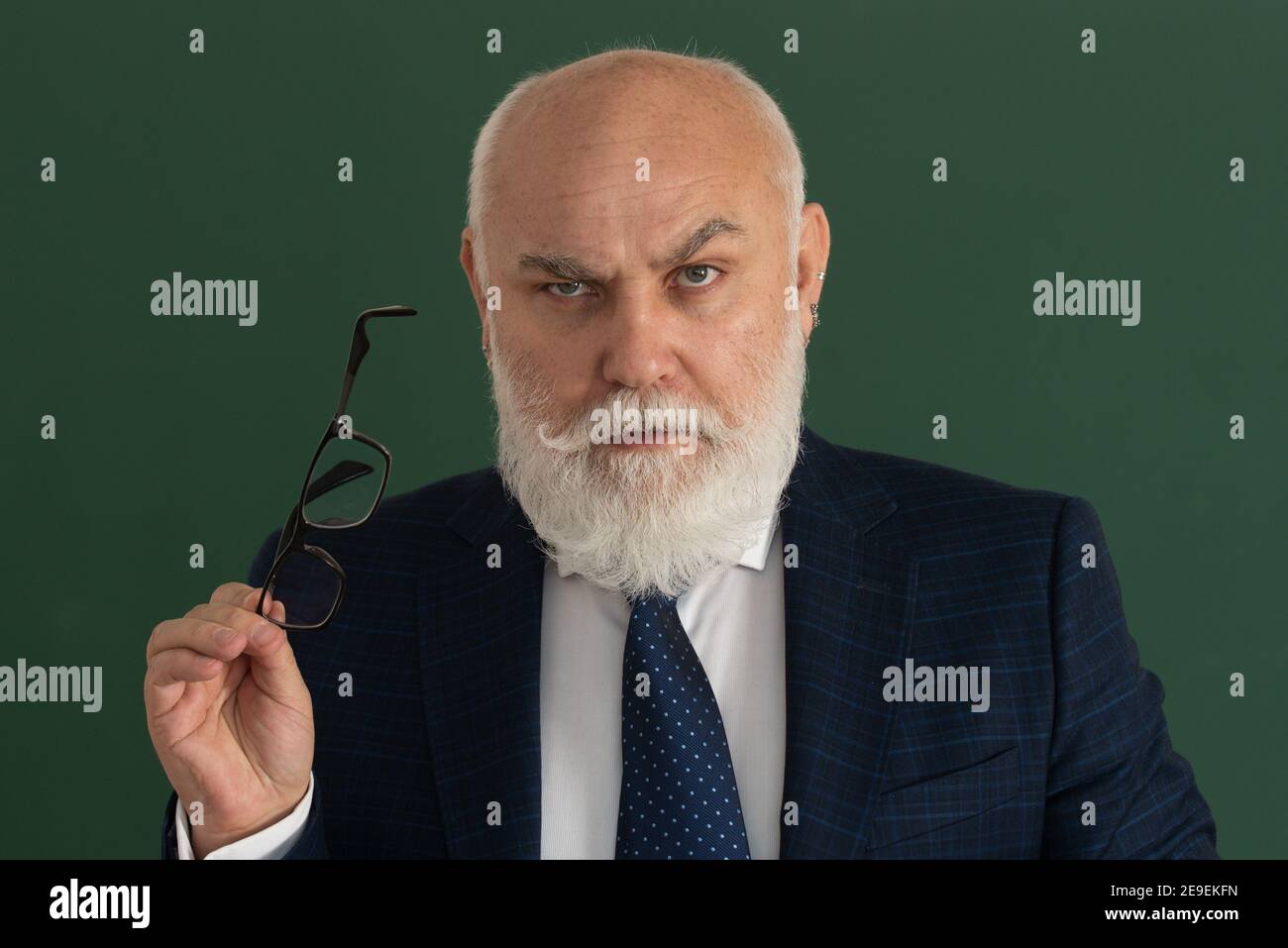 Professor or serious teacher. Elderly man teacher on a blank chalkboard ...