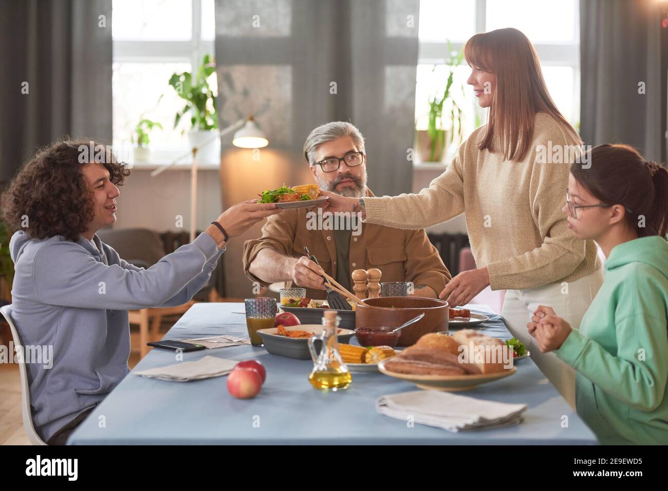 Family sitting at dinner table they are going to have dinner in the ...