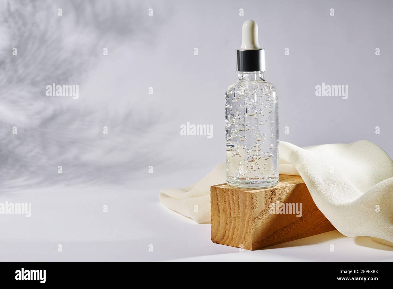 Anti aging serum in a glass bottle on a gray background. Facial liquid ...