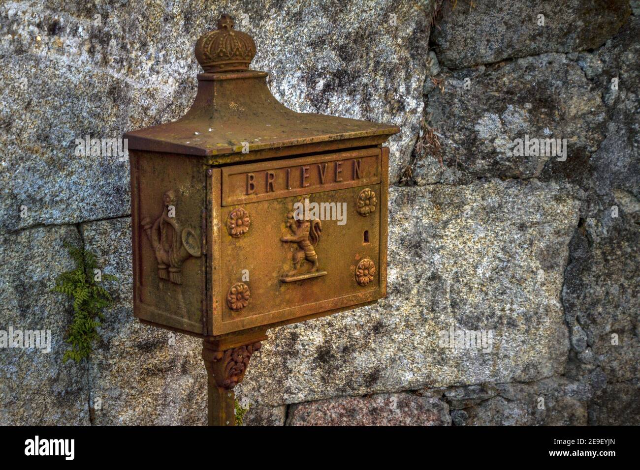Rusty old mailbox on a stone wal Stock Photo - Alamy
