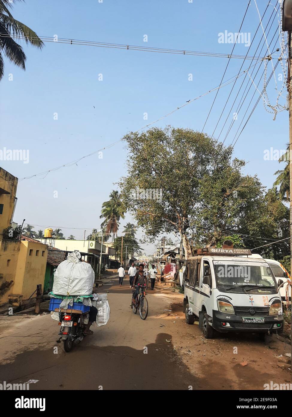 MALAVALLI, INDIA - Feb 01, 2021: a road with vehicles and buildings ...