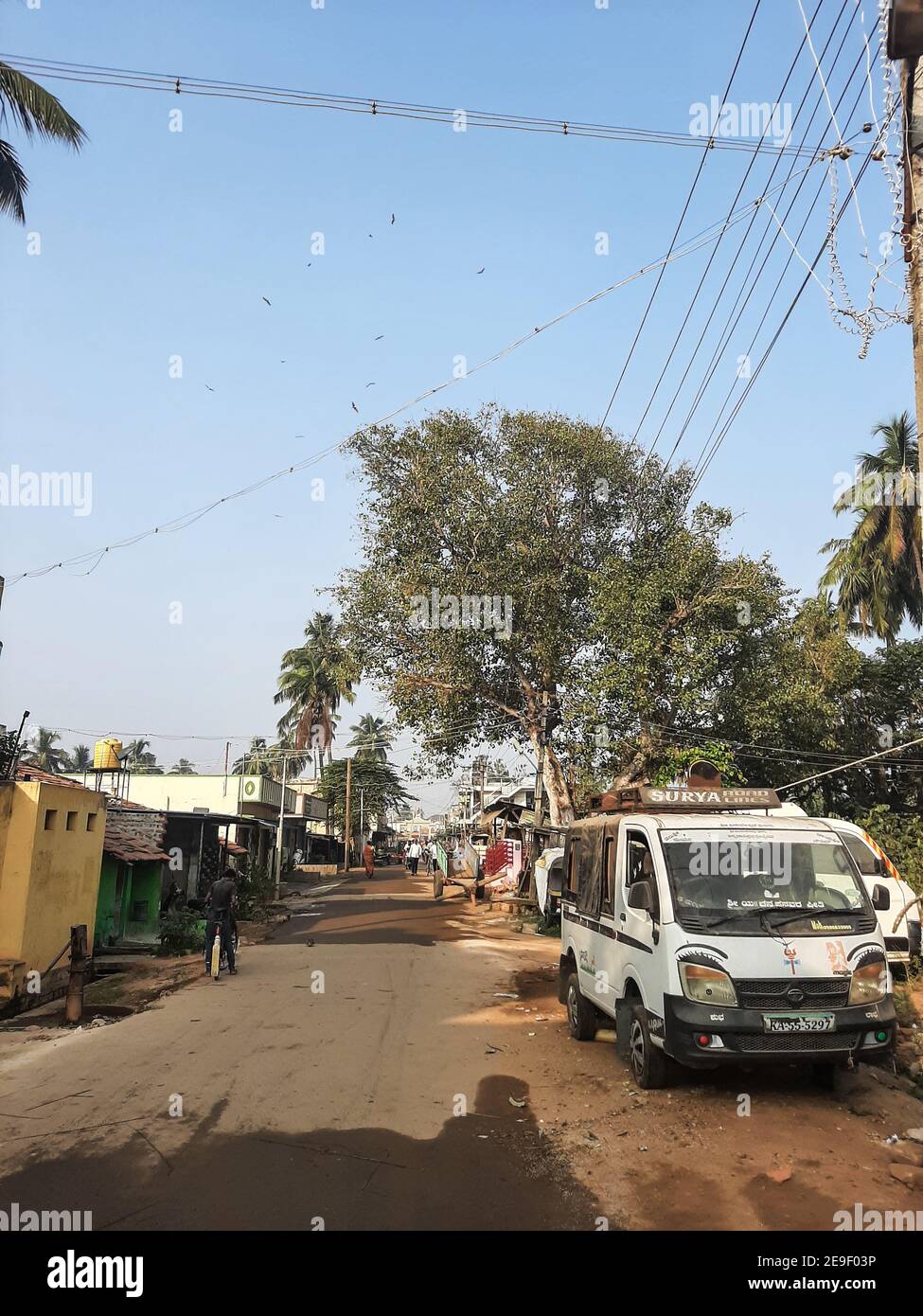 MALAVALLI, INDIA - Feb 01, 2021: a road with vehicles and buildings ...