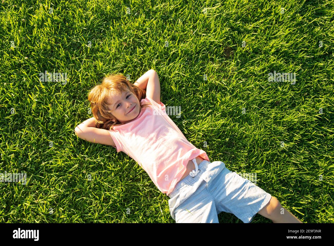 Happy Child Lying On Grass Background Cute Kid Child Boy Enjoying On