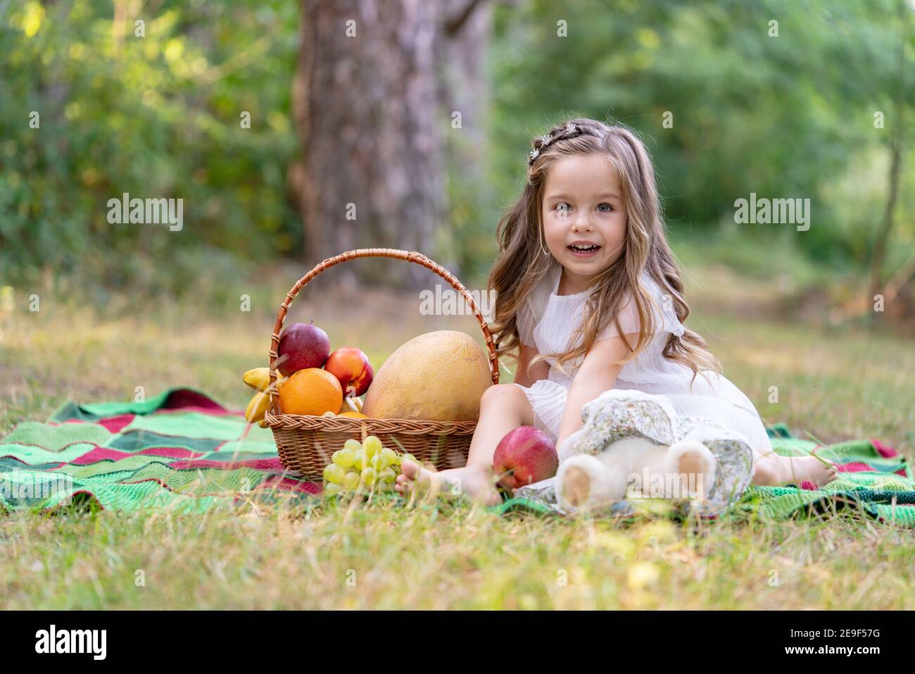 Forest girl on picnic with basket, Kid in sunny park or garden. Little ...
