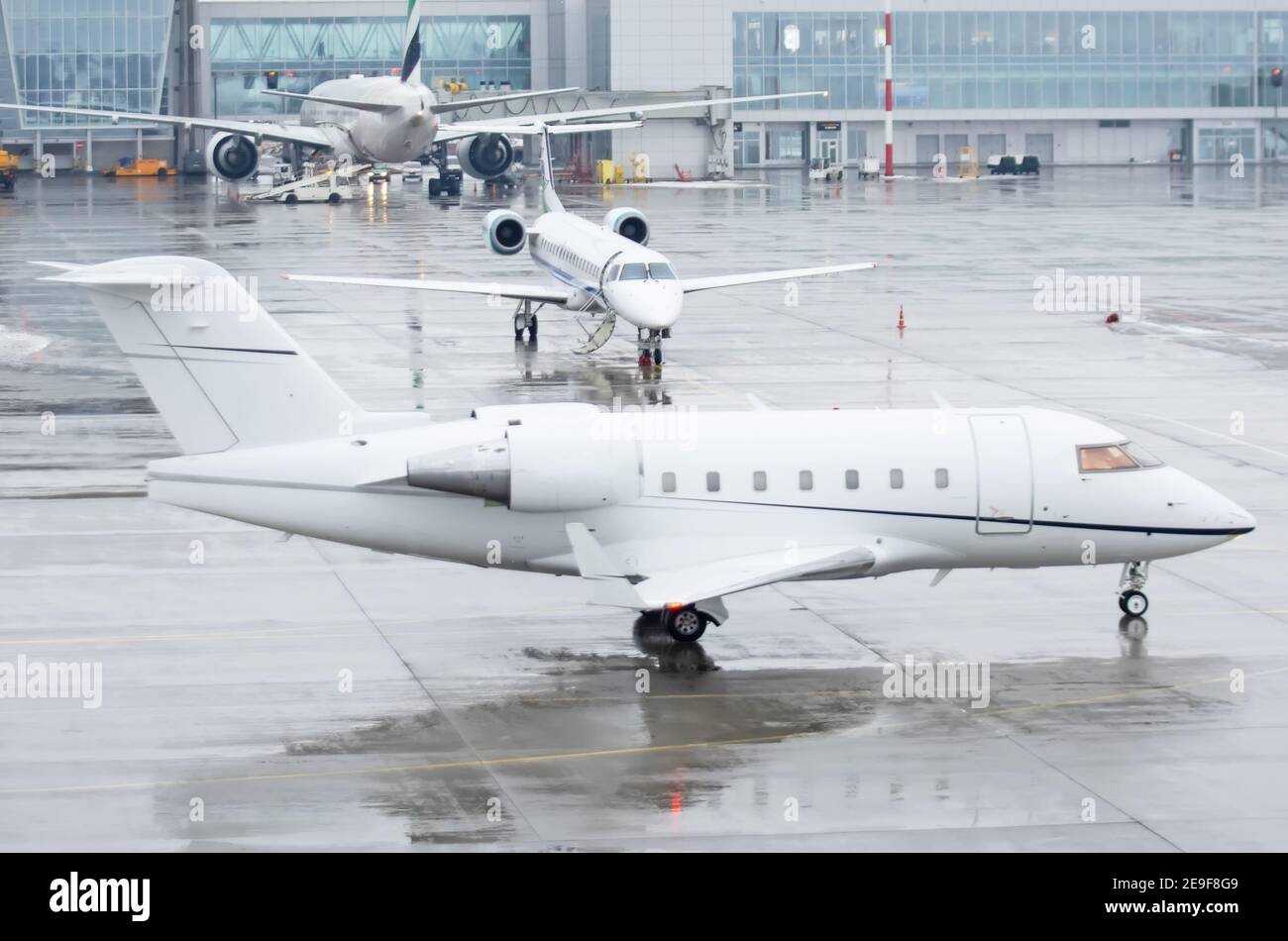 A small business jet is taxiing after landing on the airport apron ...