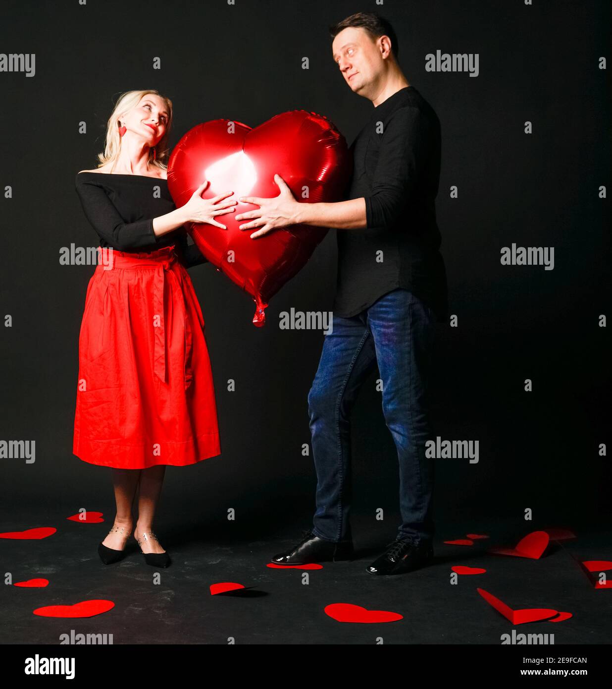 A girl and a guy hold a heart ball inflatable love red, Valentine's day ...