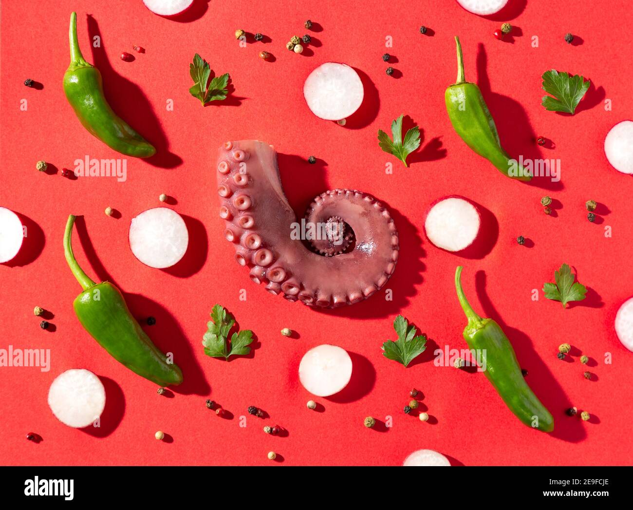 Flat lay composition of tentacle of stew octopus and pepers on red ...