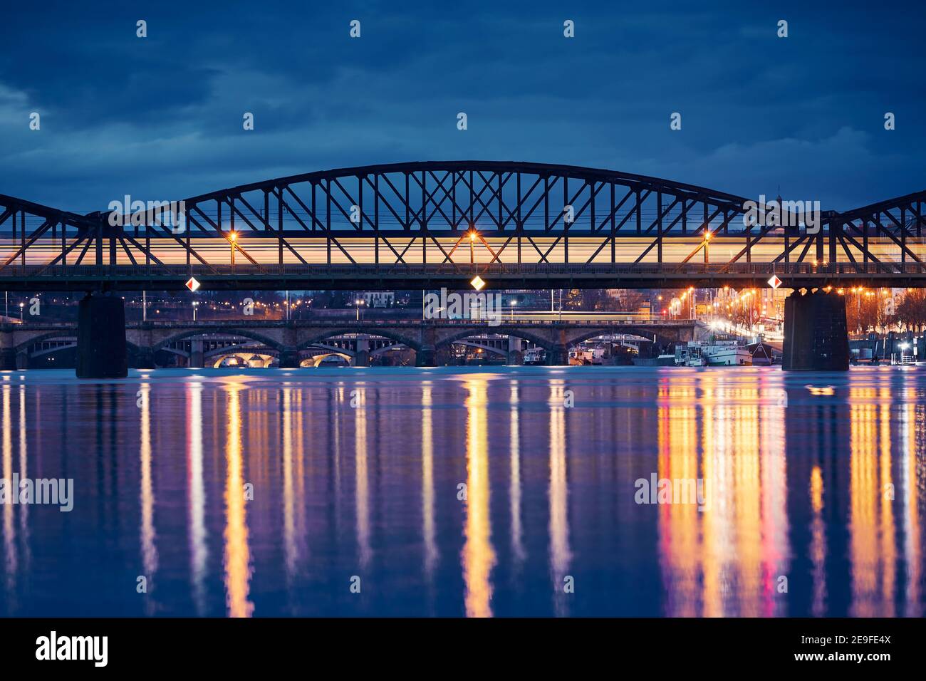 Passenger train passing over railway bridge against city. Cityscape of ...