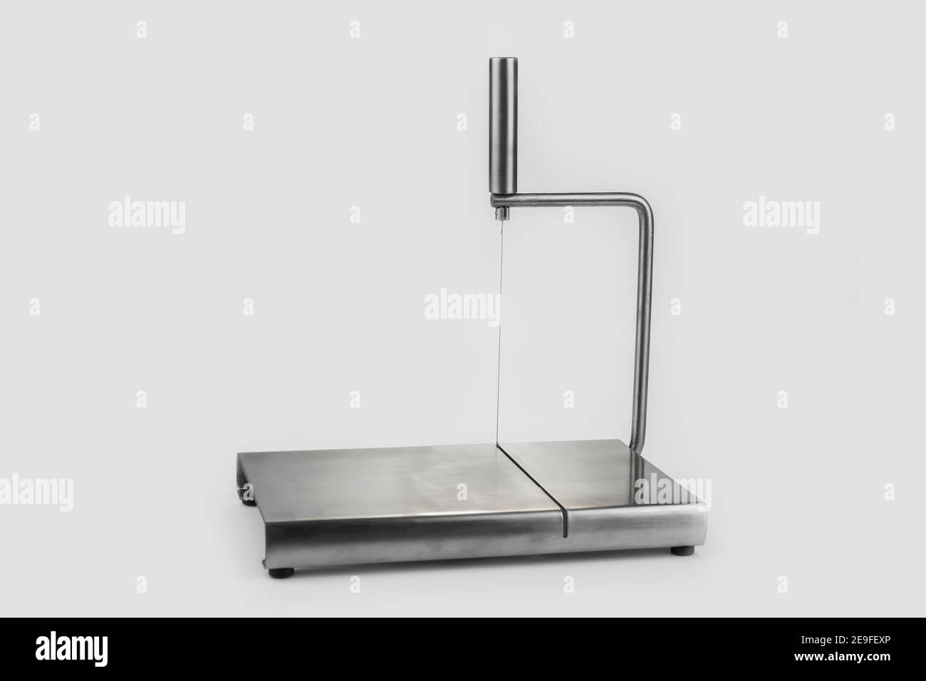 Wire Hand kitchen Cheese slicer cutter on a white Stock Photo - Alamy