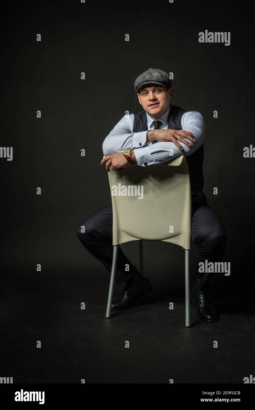 in a cap on a chair Young male three piece suit male caucasian isolated ...