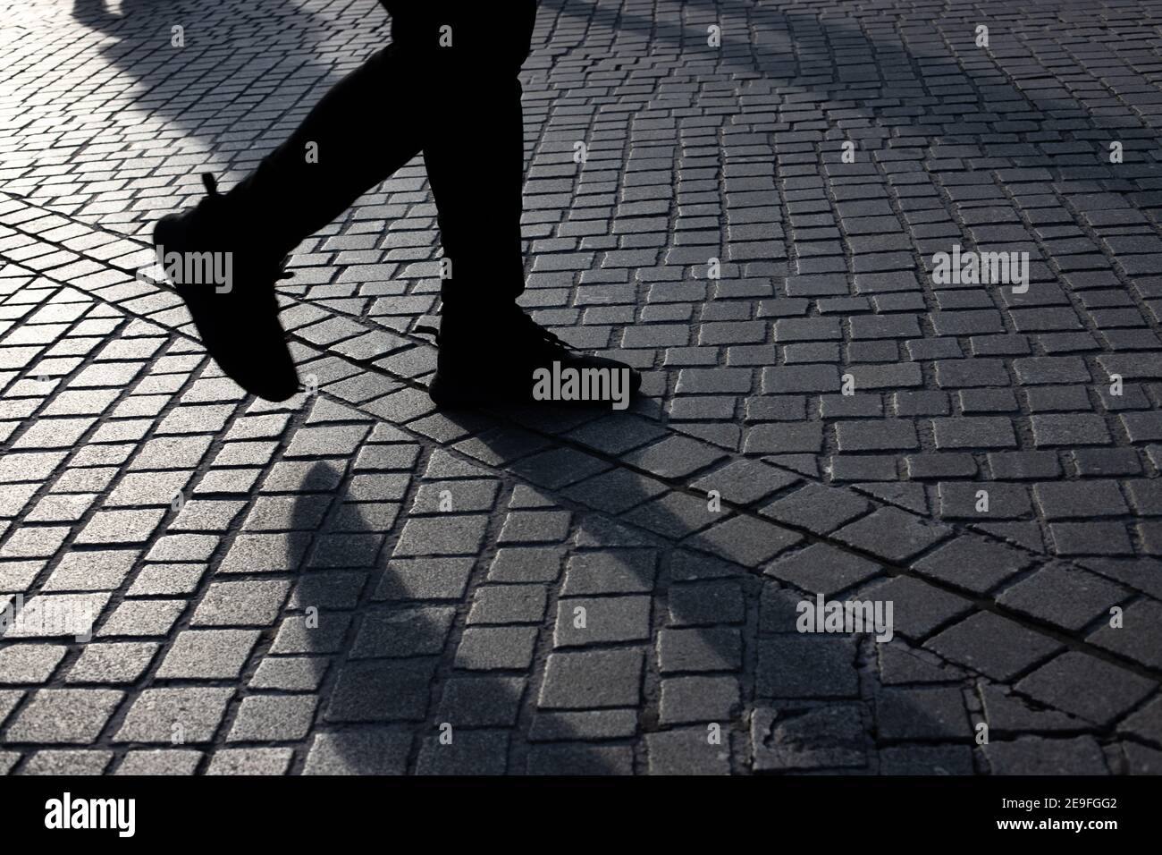 Detail of people rushing over the pavement at a train station during ...