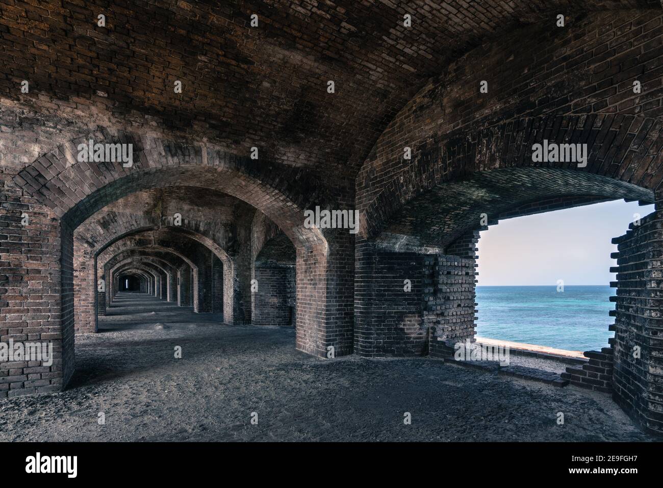 Archway corridor of an old military fort. Ocean viwe through window in ...