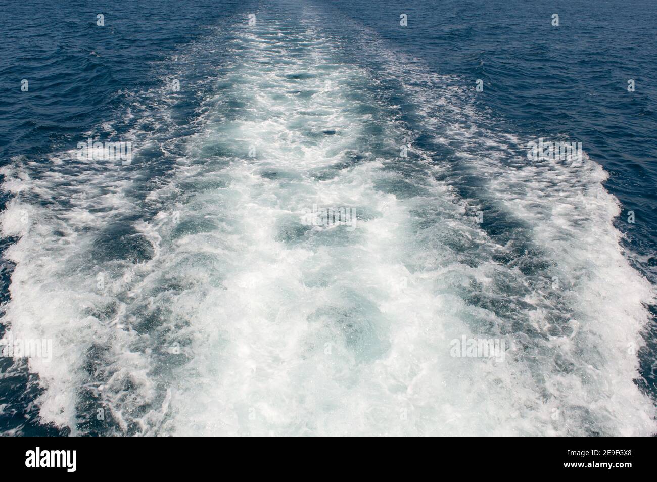 Wake behind the ferry boat leaving the sea foam and wave pattern on the ...