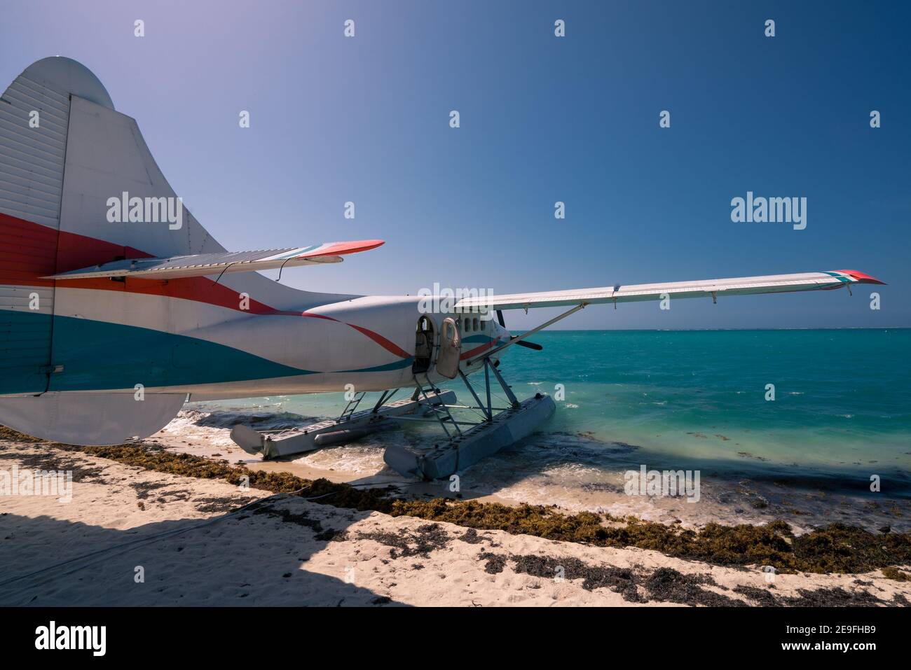 Small hydroplane sitting on a beach of an island. Beautiful summer day ...