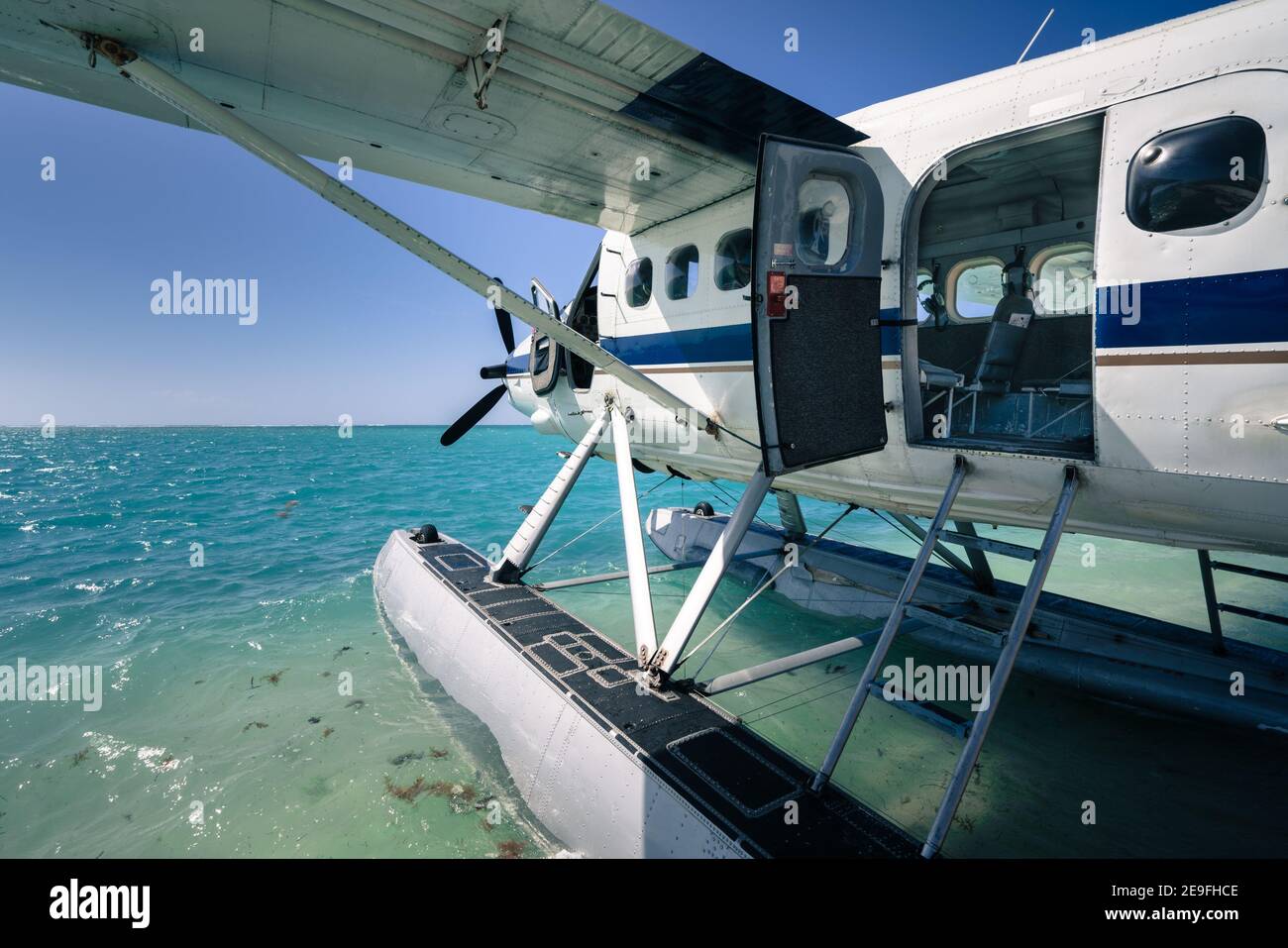 Small hydroplane sitting on a beach of an island. Beautiful summer day ...