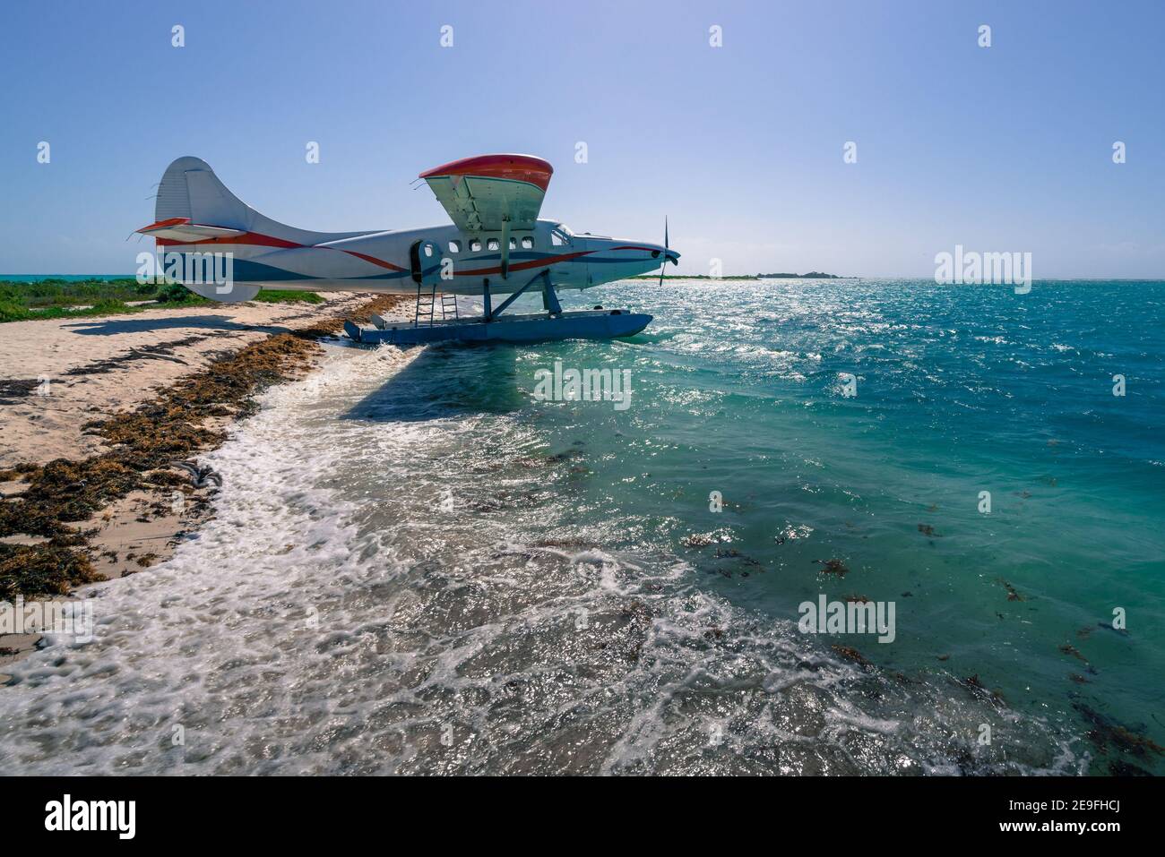 Small hydroplane sitting on a beach of an island. Beautiful summer day ...