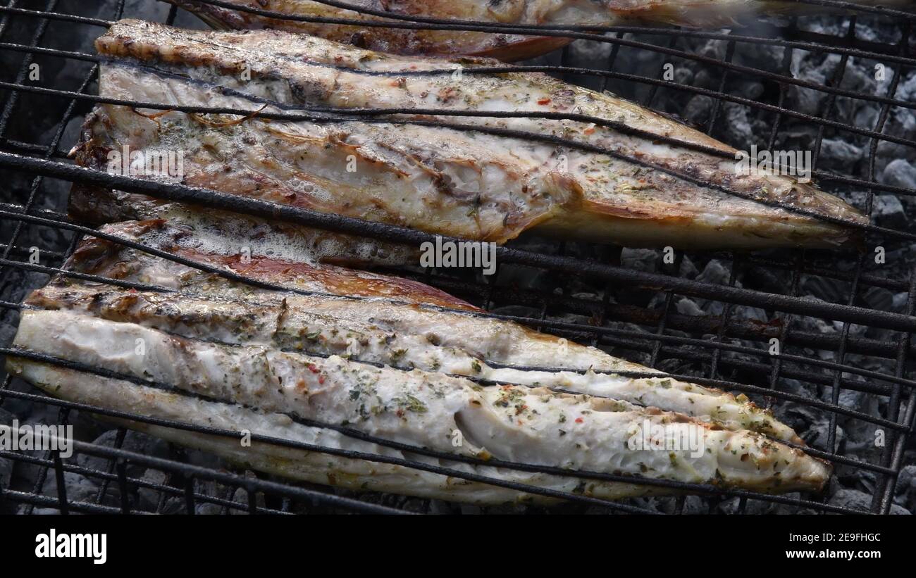 Juicy grilled mackerel fish inside grill grid on charcoal brazier. Fish ...