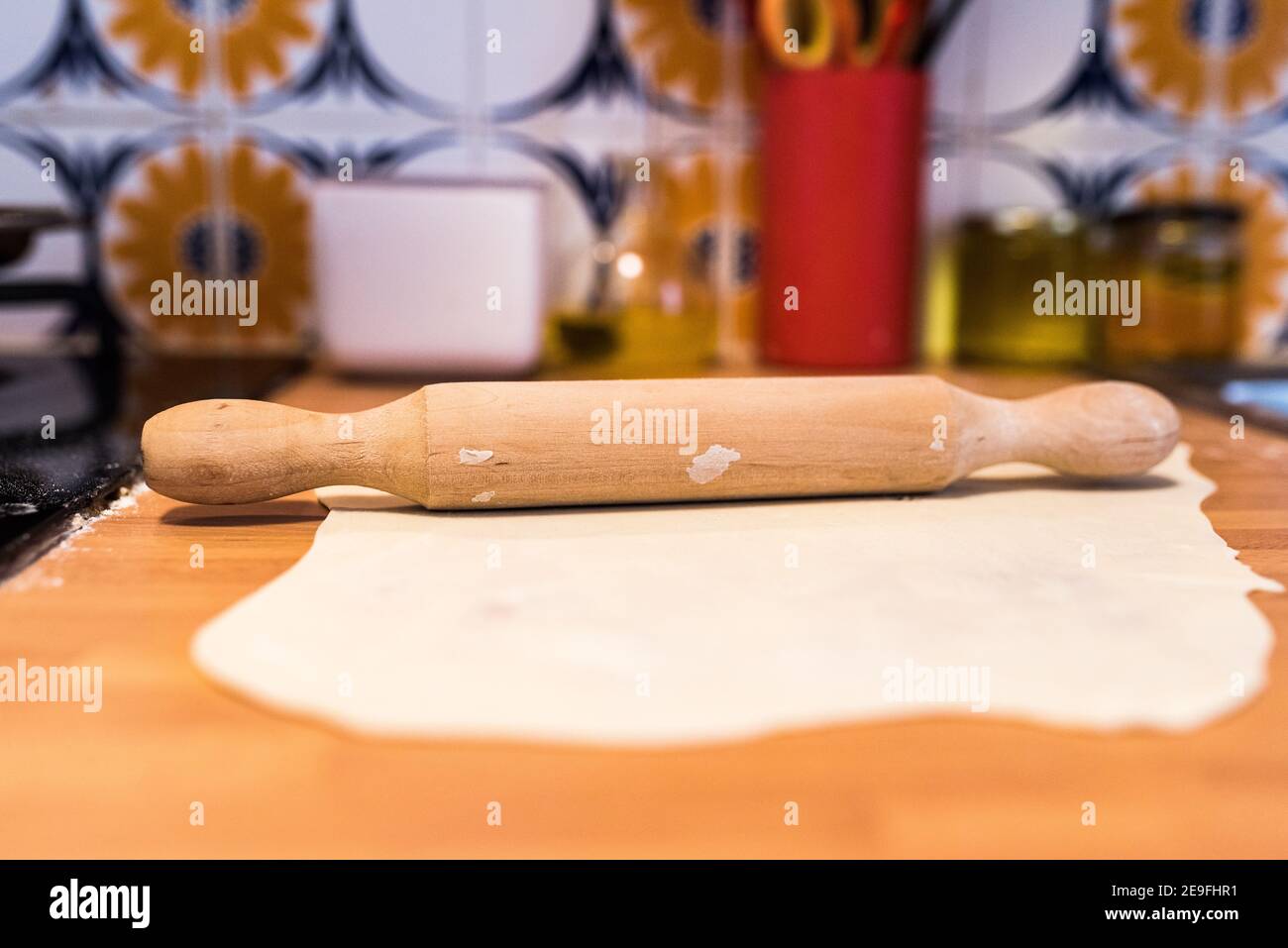 Kitchen rolling pin to shape dough filled with flour. Shaping dough ...
