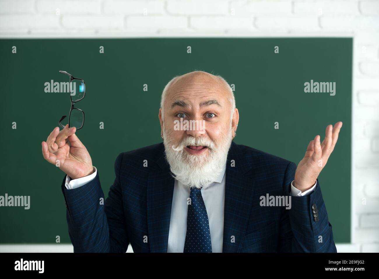 Senior academic professor on lecture near empty blackboard. Knowledge ...