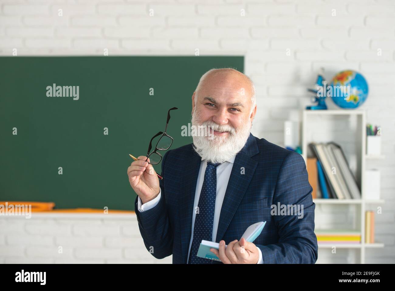 Grey hair funny happy smiling professor in empty lecture classroom ...