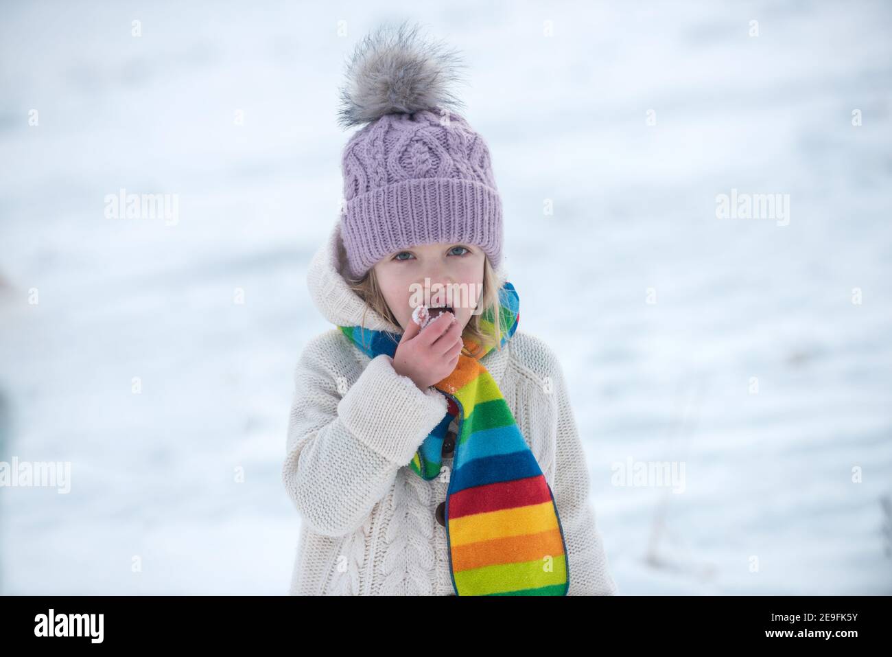 Child eat snowflakes. Kid girl lick and eating snow in winter. Winter ...