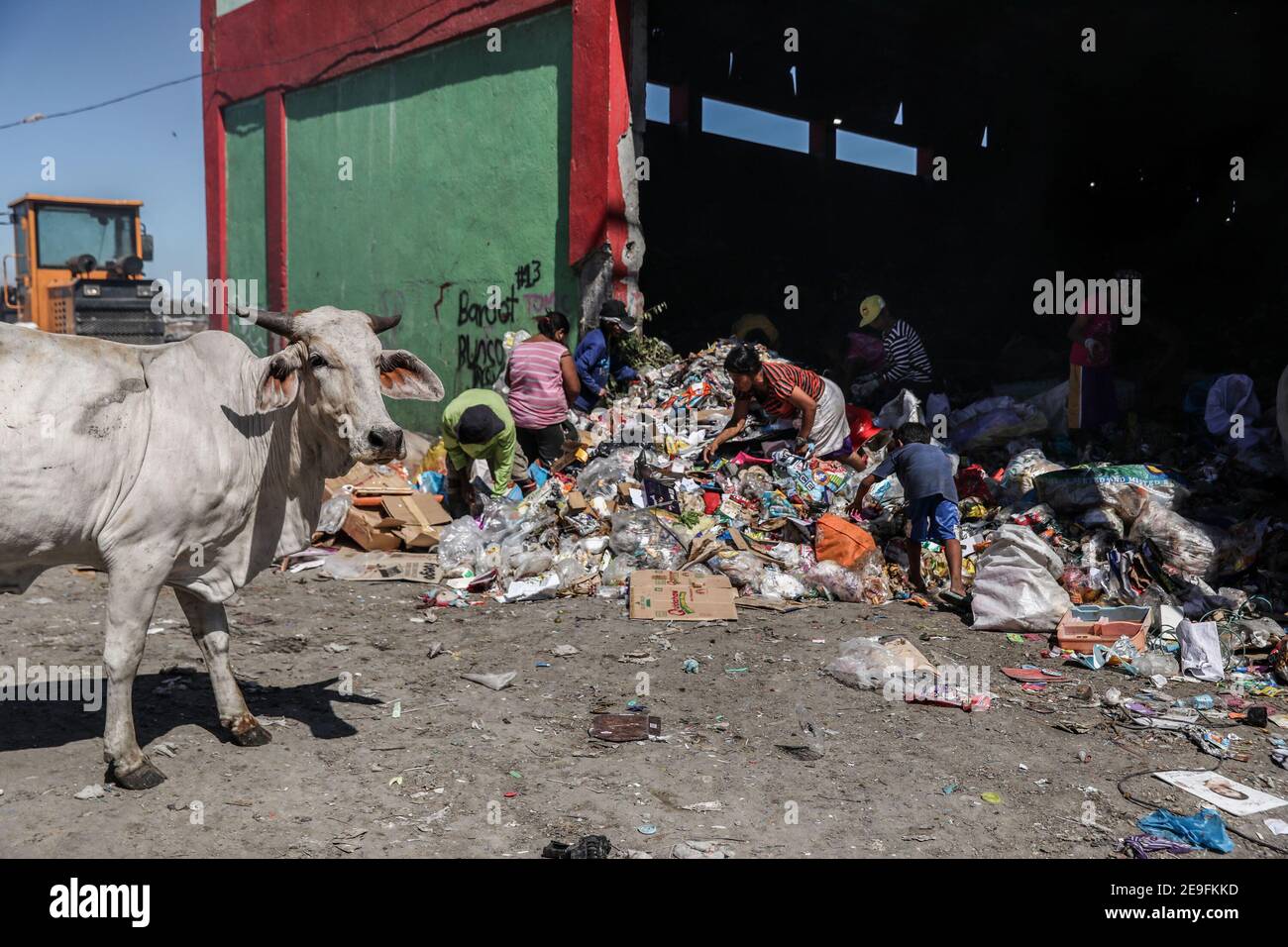 People collect materials to recycle at a garbage site in the town of ...