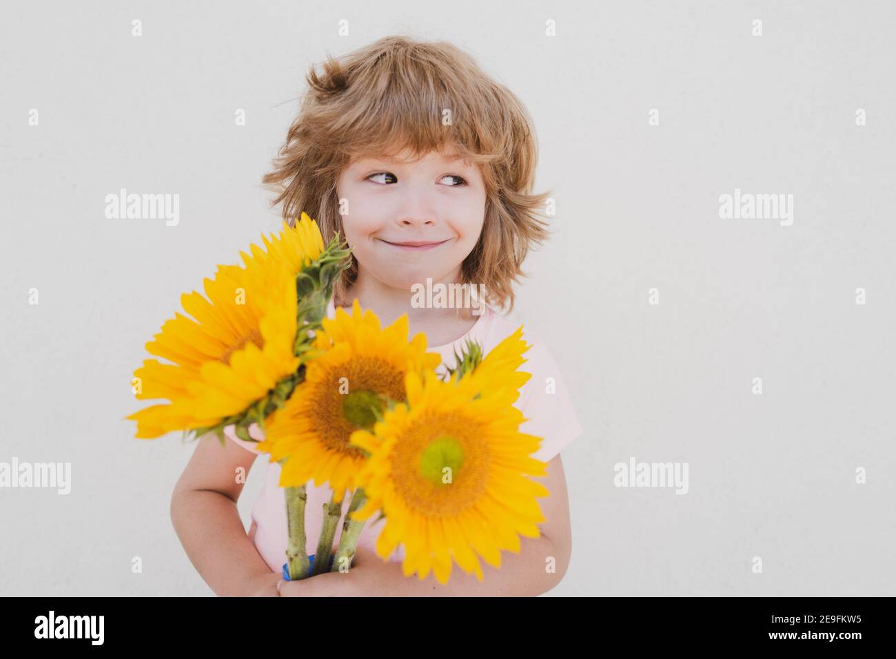 Smiling kid with sunflowers. Happy child with bouquet of flowers. Cute ...