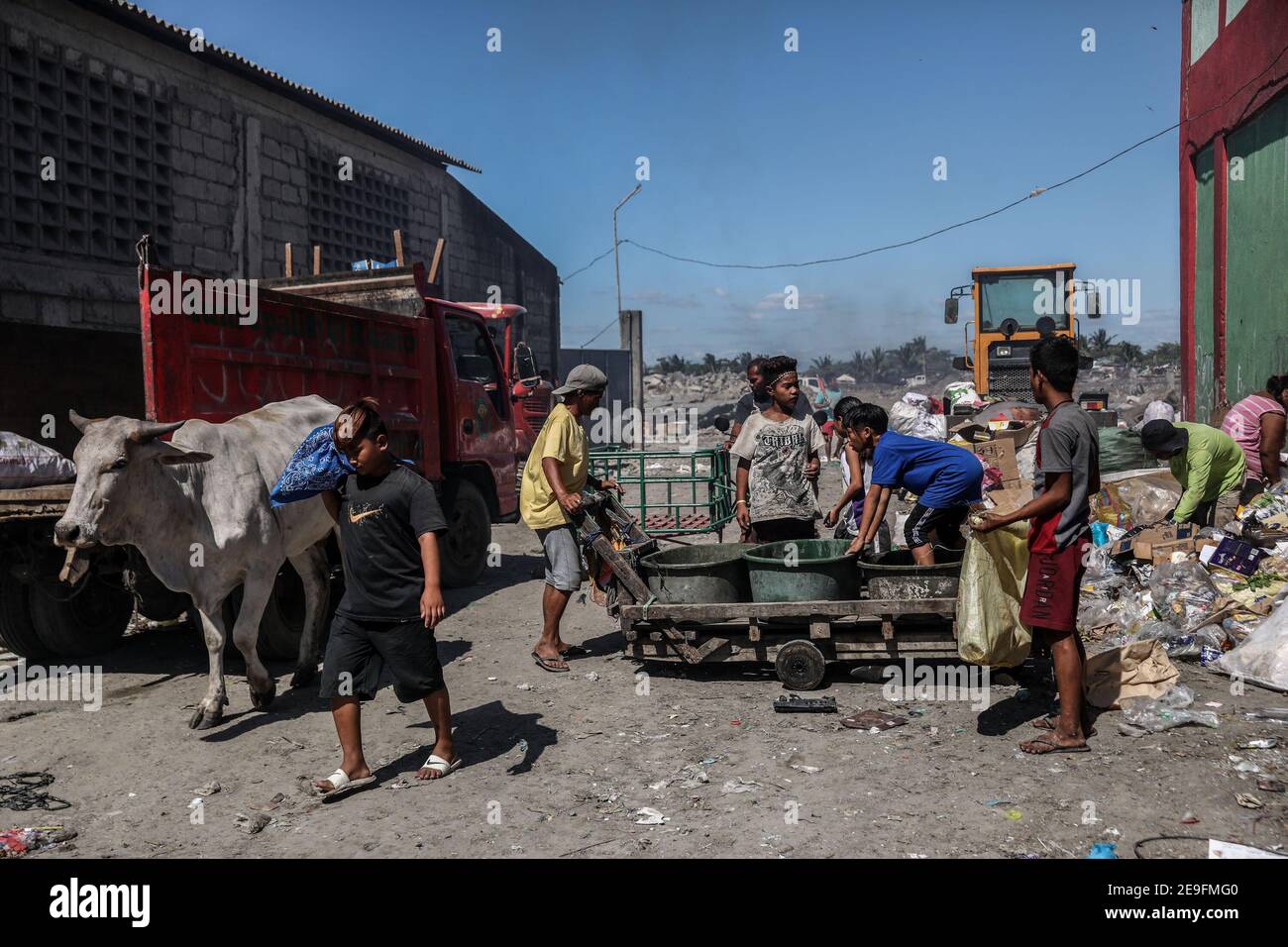 Workers collect recyclable materials at a garbage site in the town of ...