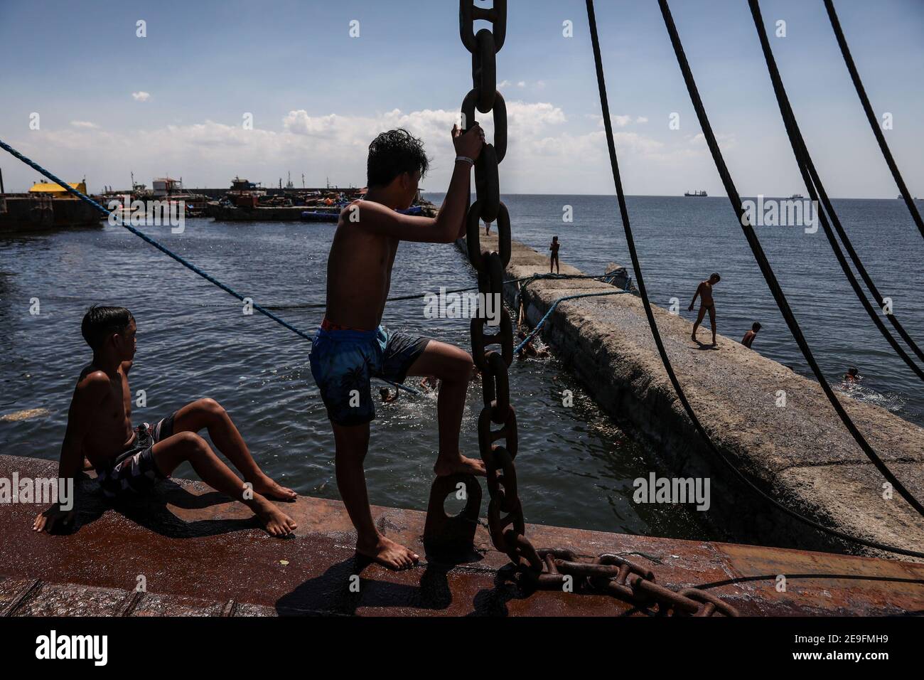 Children use boats docked near the Baseco compound in Manila as ...