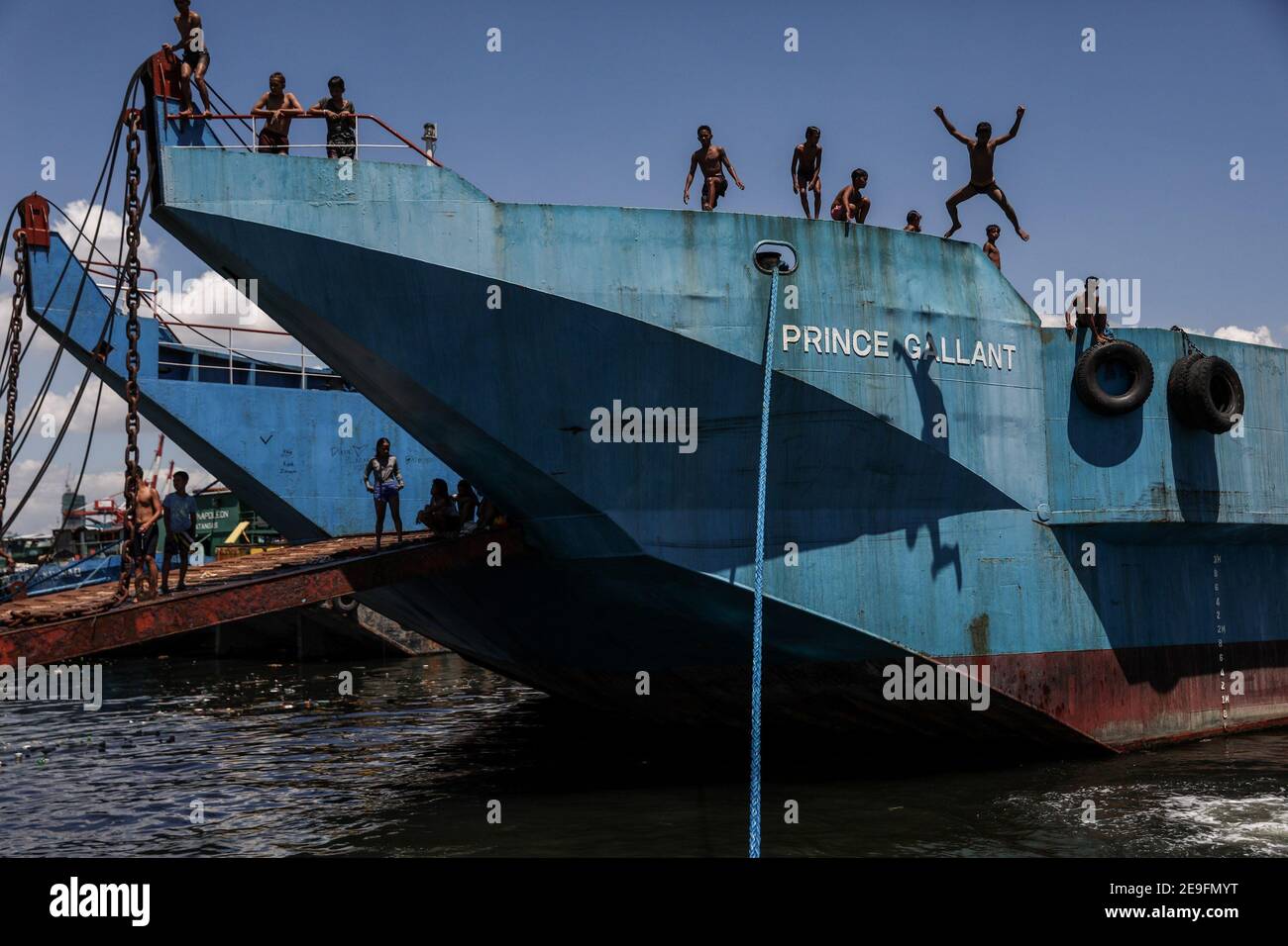 Children use boats docked near the Baseco compound in Manila as ...