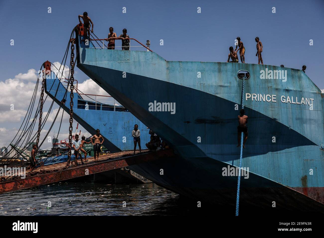 Children use boats docked near the Baseco compound in Manila as ...