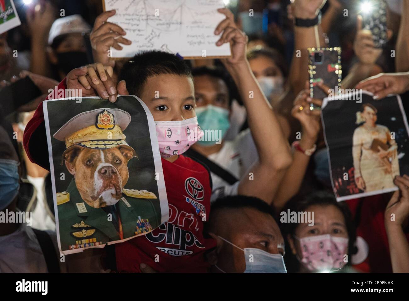 A protester holding the Min Aung Hlaing portrait depicted as a dog ...