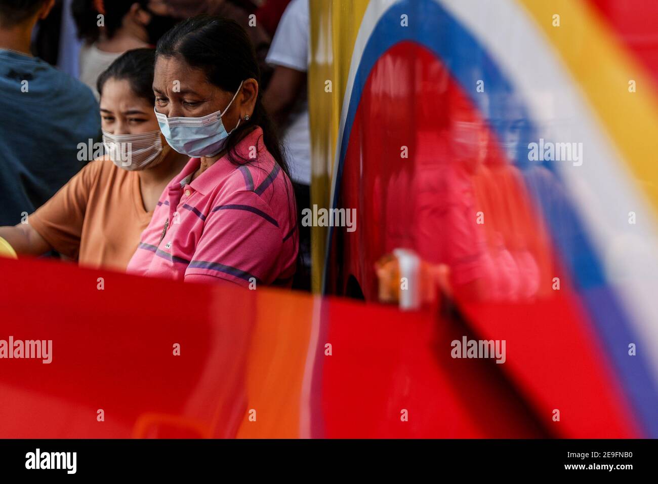People wearing protective masks flock to a bus terminal during a COVID ...