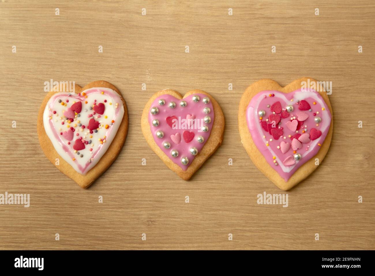 A photograph of three heart shaped biscuits from above, background of ...