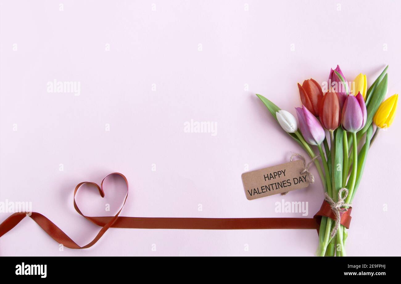Heart shape ribbon attached to a bunch of flowers with valentines day ...
