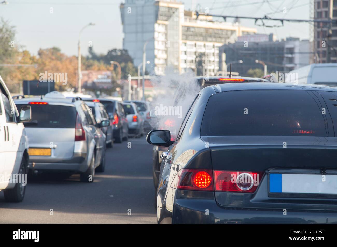 Vapour smoke go out from a car at a traffic jam. There are a lot of ...