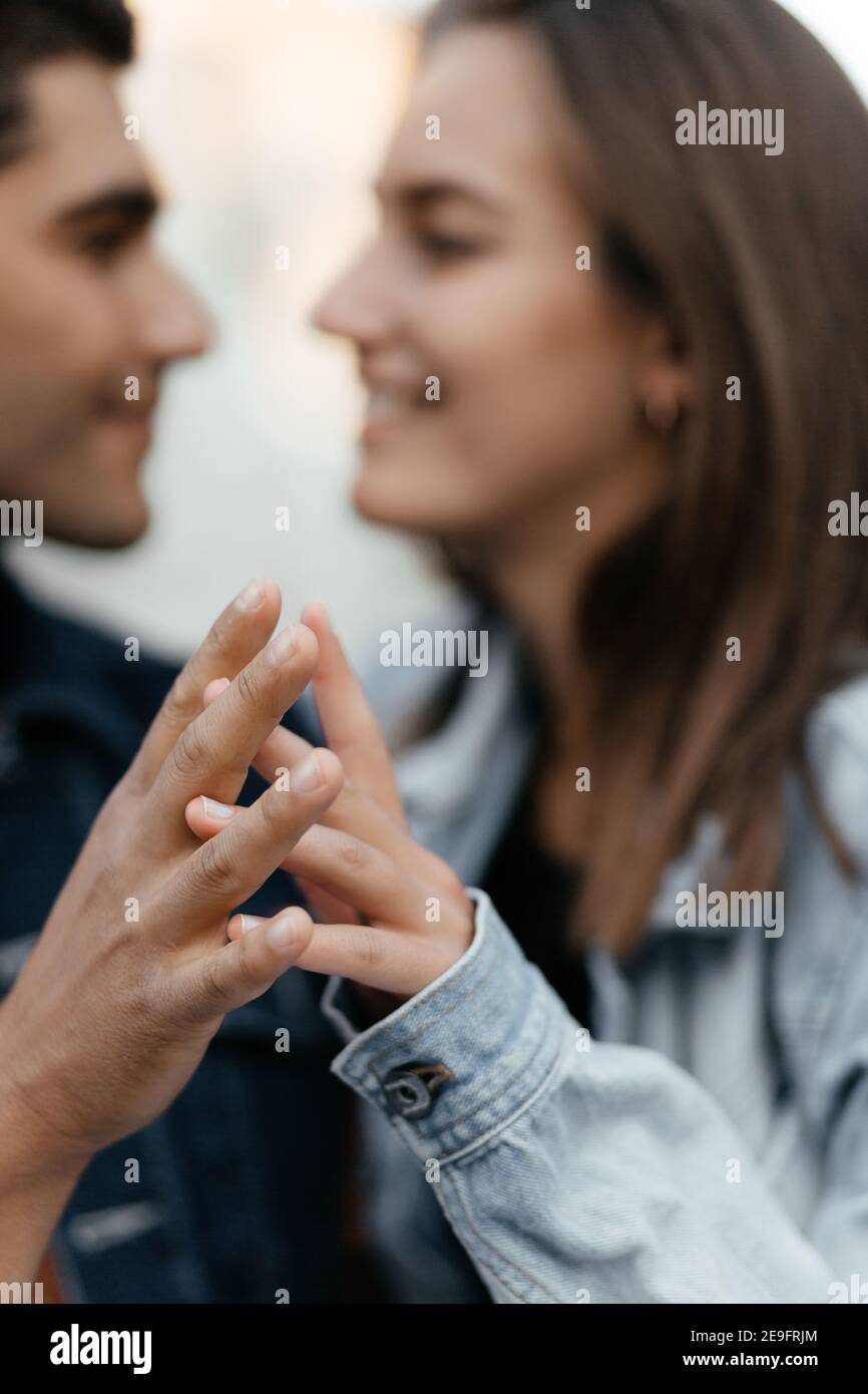 Lovers hands at the background of blurred man and woman faces ...