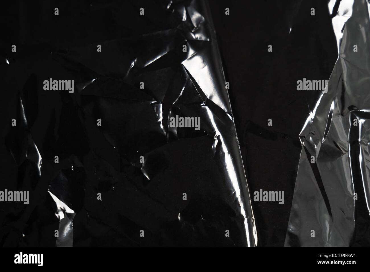 Real transparent plastic wrap on black background. Disposable film for ...